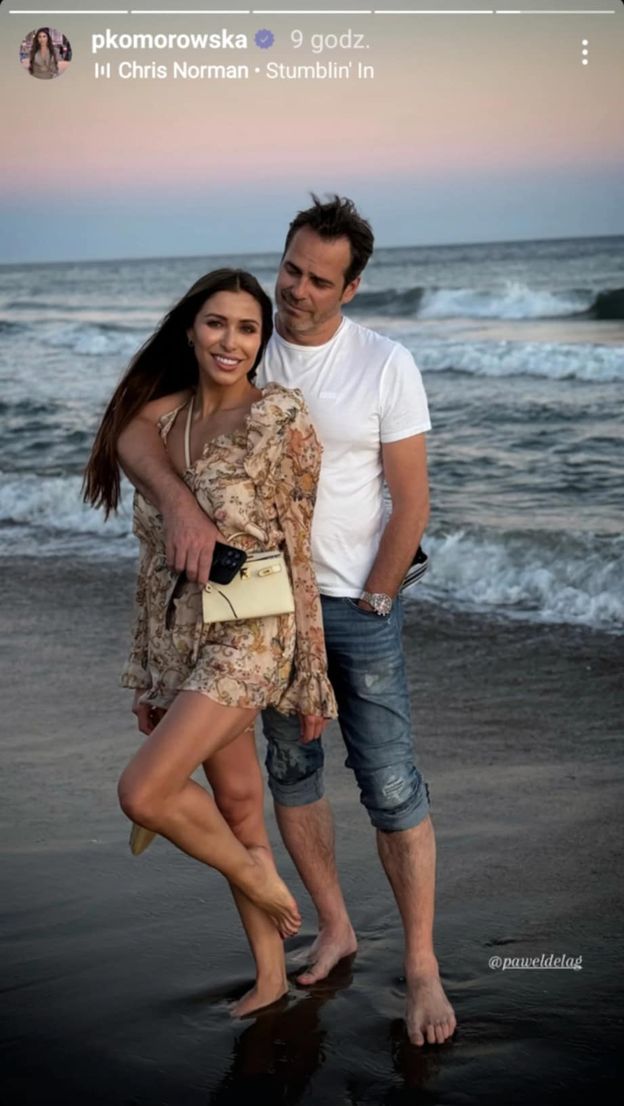 Muskani wiatrem Paweł Deląg i jego ukochana na plaży. Miłość kwitnie? - Pudelek